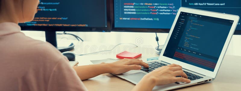 Female Developer Coding On Laptop While Computer Display Program