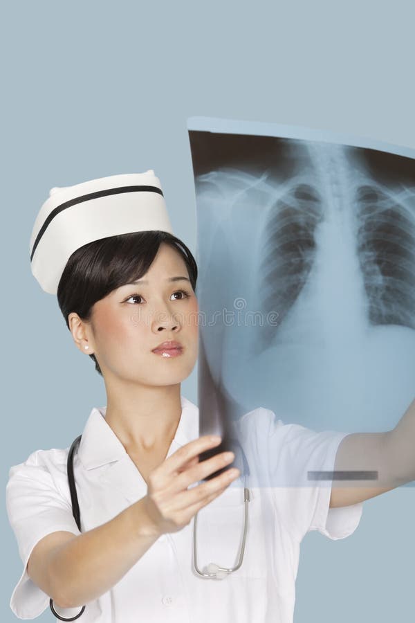 Midsection of a Female Doctor Reading Medical Report Over Light Blue ...