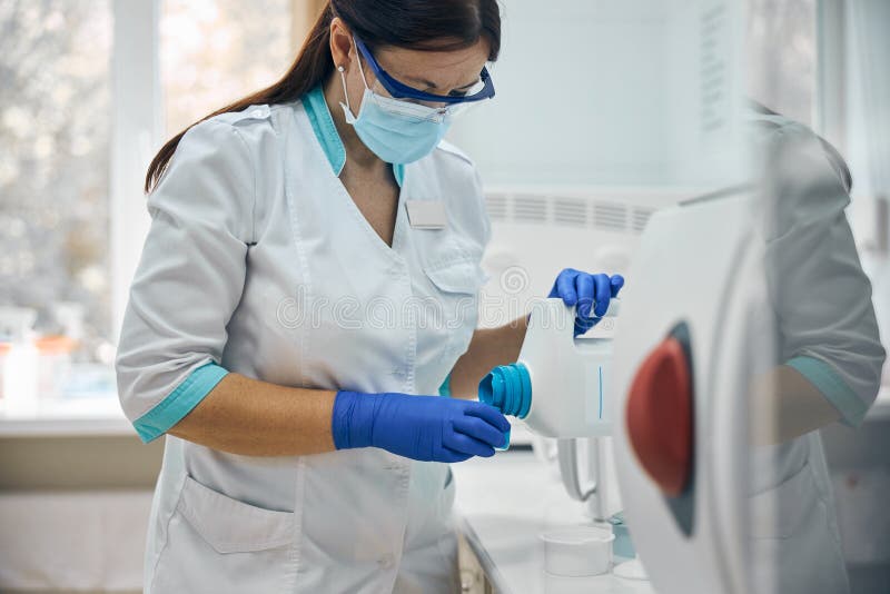Female Doctor with Bottle of Solution for Work with Instruments Stock ...