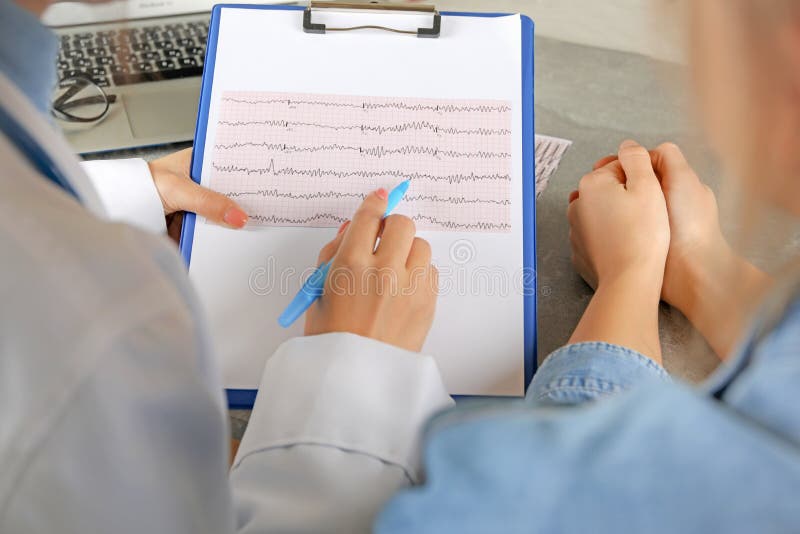 Female Doctor Checking Electrocardiogram Results with Patient Stock ...