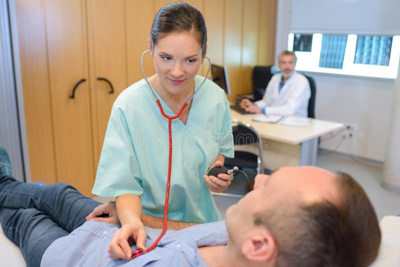 Female Doctor Checking on Patient Heart Rate Stock Image - Image of ...