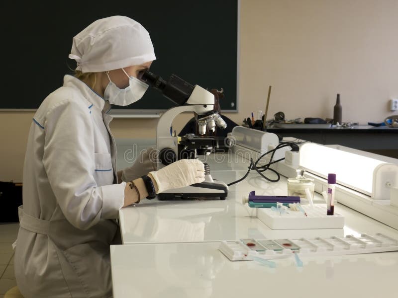 A Female Doctor Conducts Medical Research Using a Microscope. Stock ...