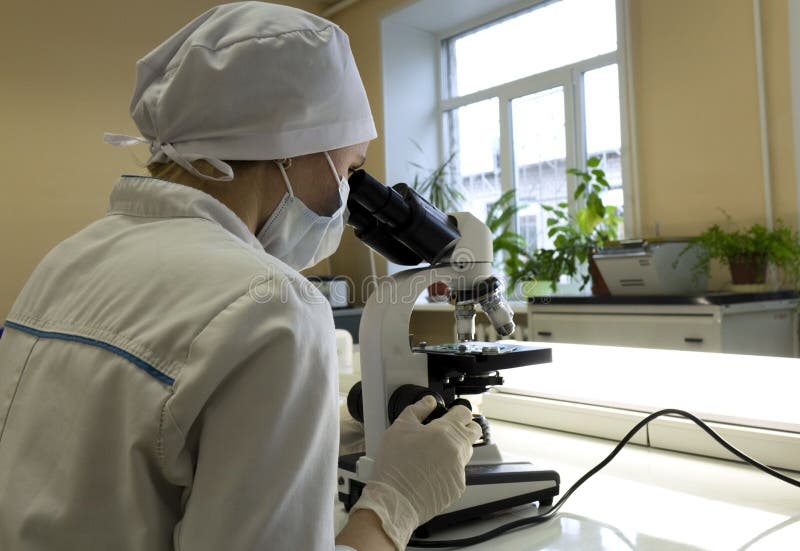A Female Doctor Conducts Medical Research Using a Microscope. Stock ...