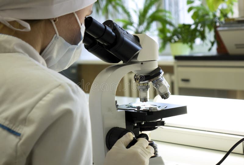 A Female Doctor Conducts Medical Research Using a Microscope. Stock ...