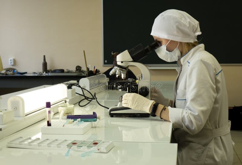 A Female Doctor Conducts Medical Research Using a Microscope. Stock ...
