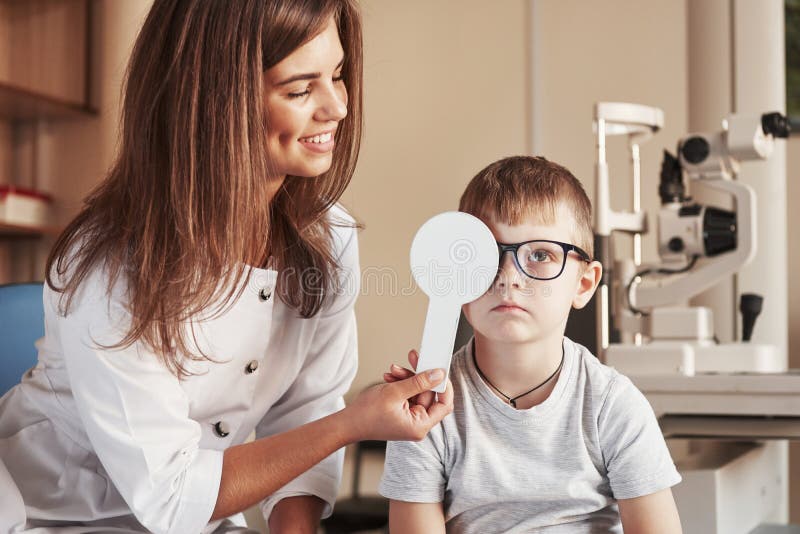 Female Doctor Covers Kid Eye with Medical Tool for Checking Visual ...