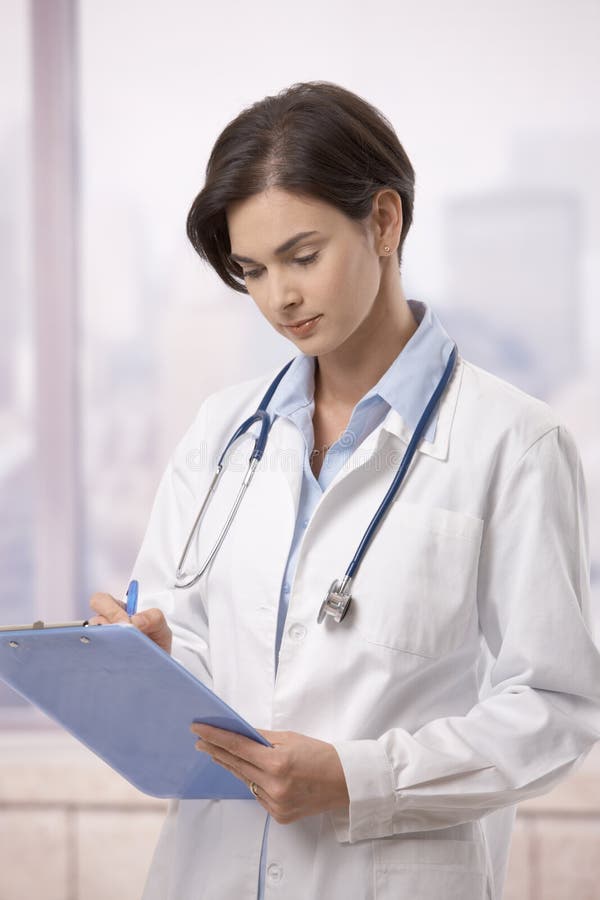 Female Doctor Doing Paperwork in Hospital Stock Image - Image of ...