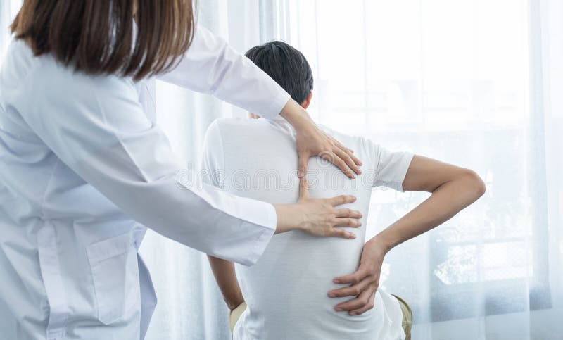Female Doctor Hands Doing Physical Therapy by Extending the Back of a ...