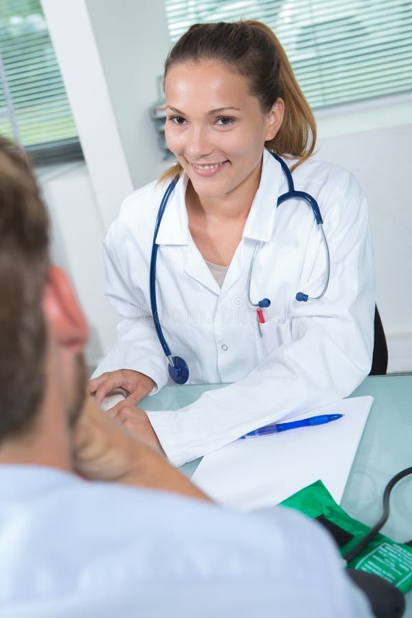 Female Doctor Looking at Patient in Clinic Stock Photo - Image of ...