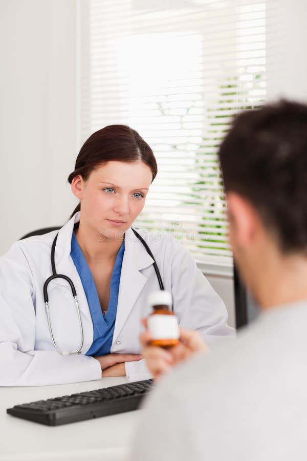 Female Doctor Looking at Patient with Pills Stock Photo - Image of ...