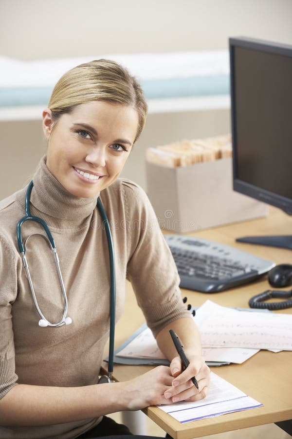 Female Doctor Sitting at Desk Stock Photo - Image of practice, british ...