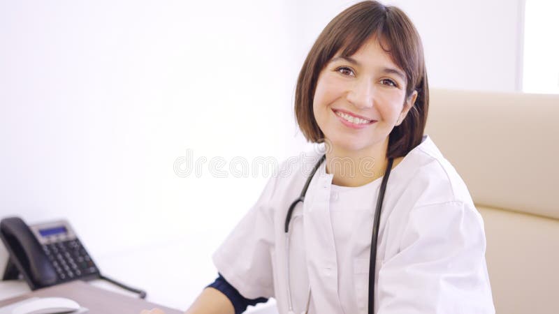 Female Doctor Smiling at Camera in Clinic Stock Photo - Image of ...