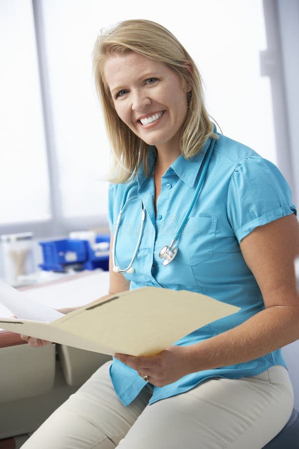 Female Doctor in Surgery Reading Patient Notes Stock Image - Image of ...