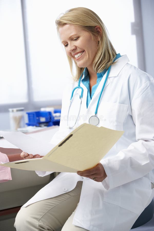 Female Doctor in Surgery Reading Patient Notes Stock Photo - Image of ...