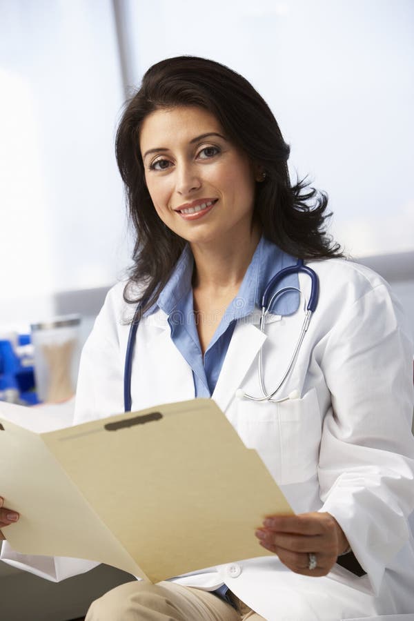 Female Doctor in Surgery Reading Patient Notes Stock Photo - Image of ...