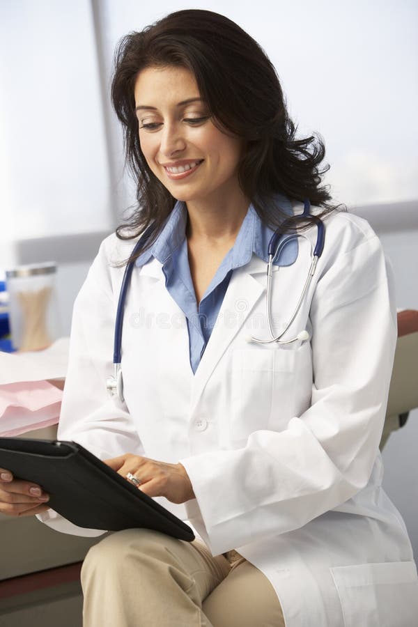 Female Doctor in Surgery Reading Patient Notes Stock Photo - Image of ...