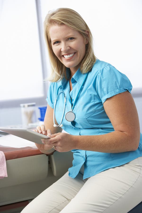 Female Doctor in Surgery Using Digital Tablet Stock Photo - Image of ...