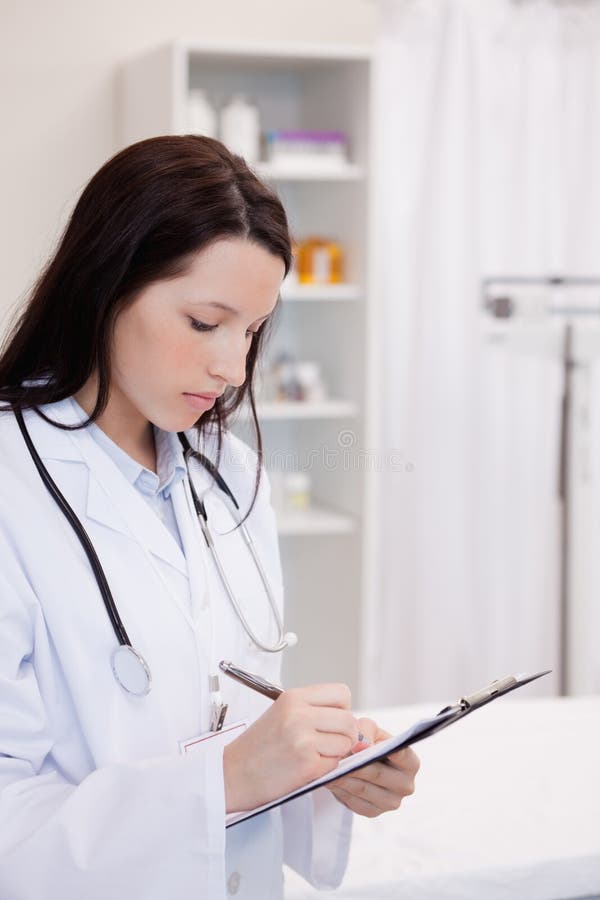 Female doctor taking notes stock image. Image of clinic - 22349447
