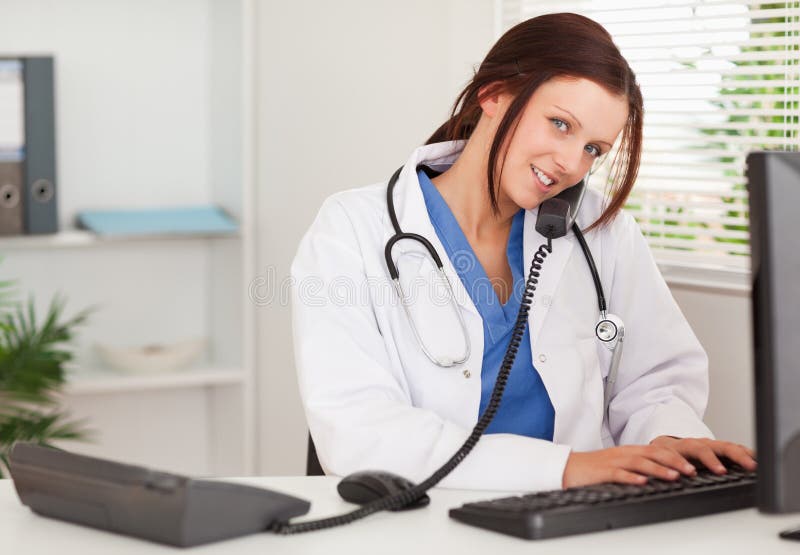 Female Doctor is Telephoning and Typing Stock Photo - Image of phone ...