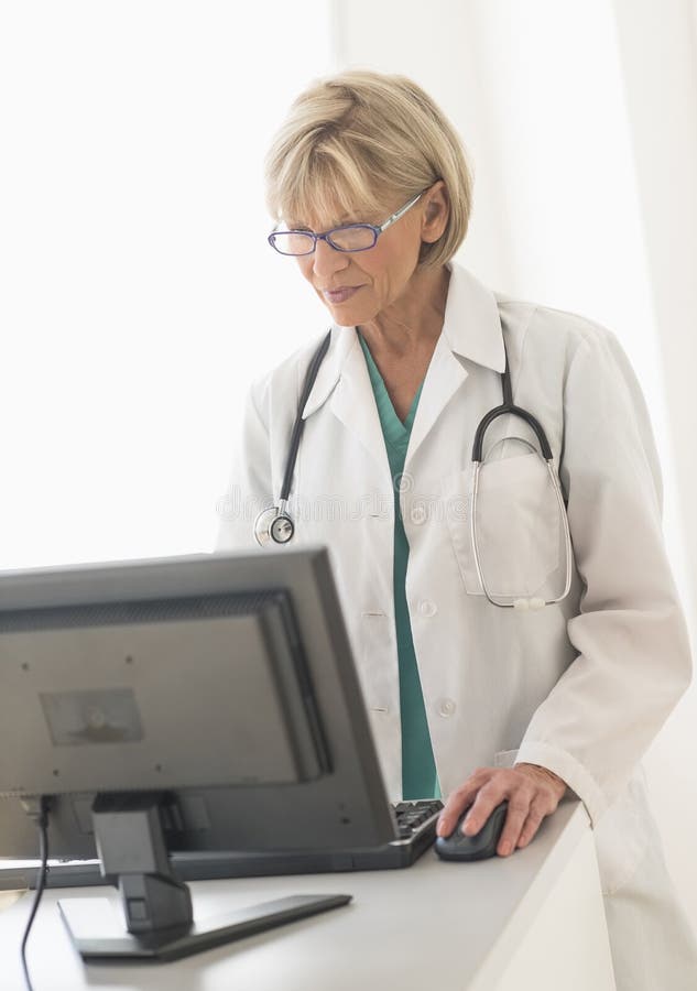 Female Doctor Using Computer at Desk Stock Image - Image of people ...