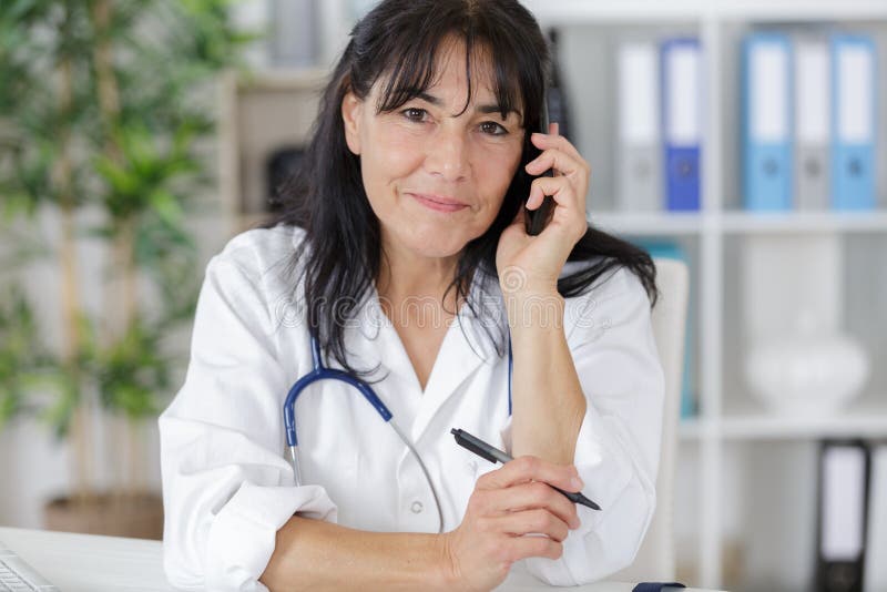 Female Doctor Using Mobile Phone in Consultation Stock Image - Image of ...