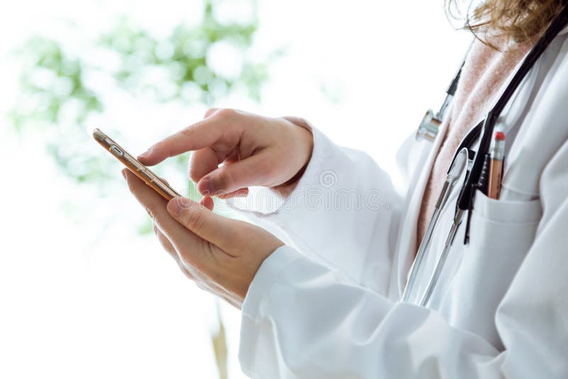 Female Doctor Using Her Mobile Phone in the Consultation. Stock Photo ...