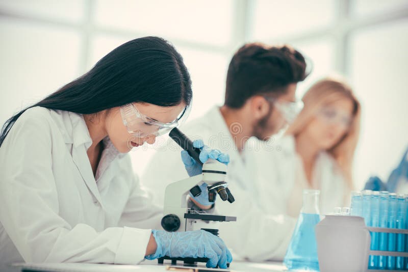 Female Doctor Using a Microscope To Check for a Coronavirus Test Stock ...
