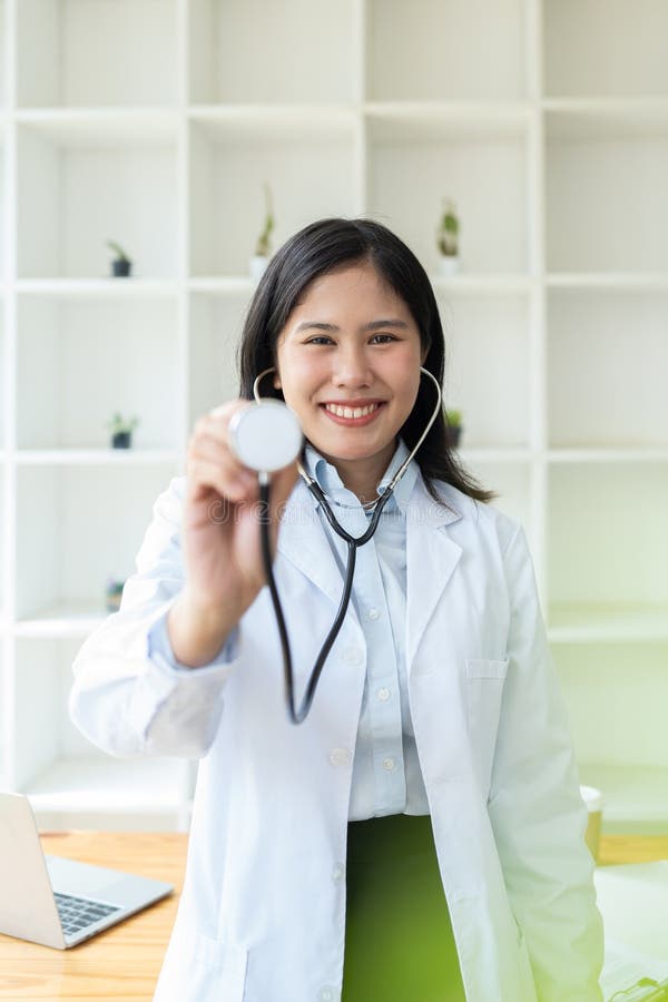 Female Doctor in a White Coat with a Stethoscope Looking at the Camera ...