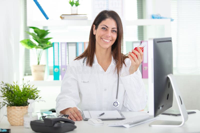 Female Doctor Working at Office Desk and Smiling at Camera Stock Photo ...