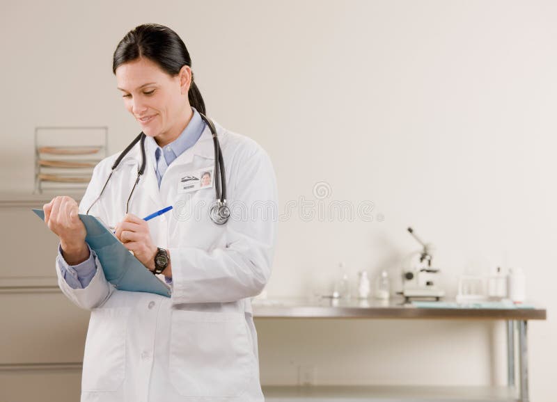 Female Doctor Writing on Medical Chart Stock Photo - Image of doctor ...