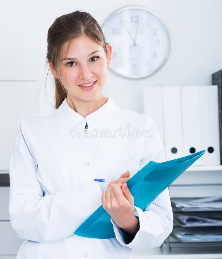 Female Doctor Writing Notes in Clinic Stock Image - Image of complaints ...