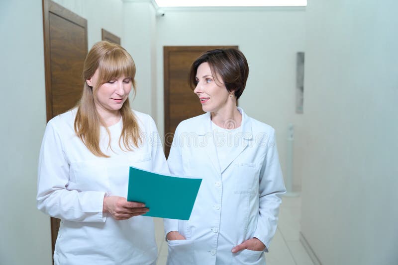 Female Doctors Walk Along the Hospital Corridor Stock Image - Image of ...