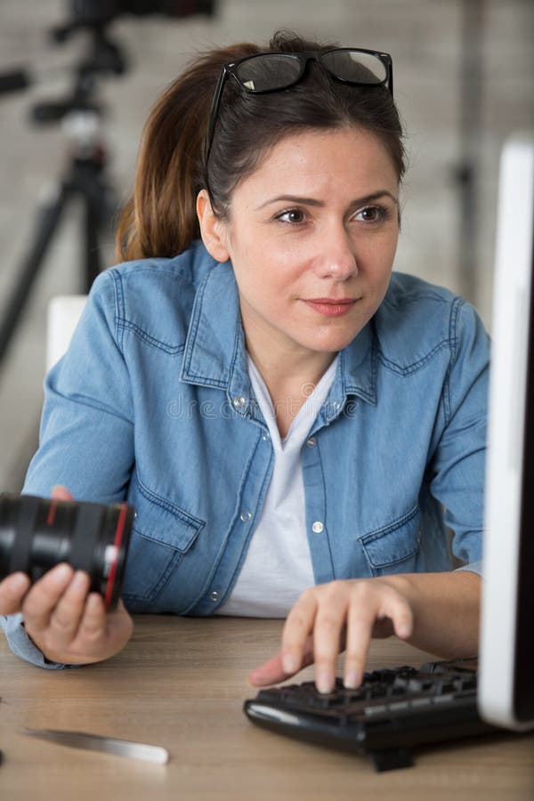 Female Editor Holding Camera Lens and Using Computer Stock Image ...