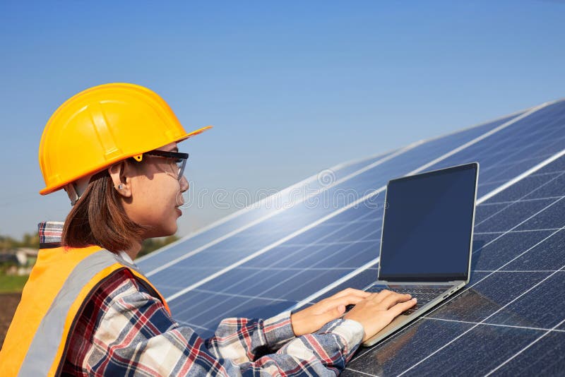 A Female Electrical Engineer is Using a Laptop To Control the Operation of the Solar Panel Stock ...