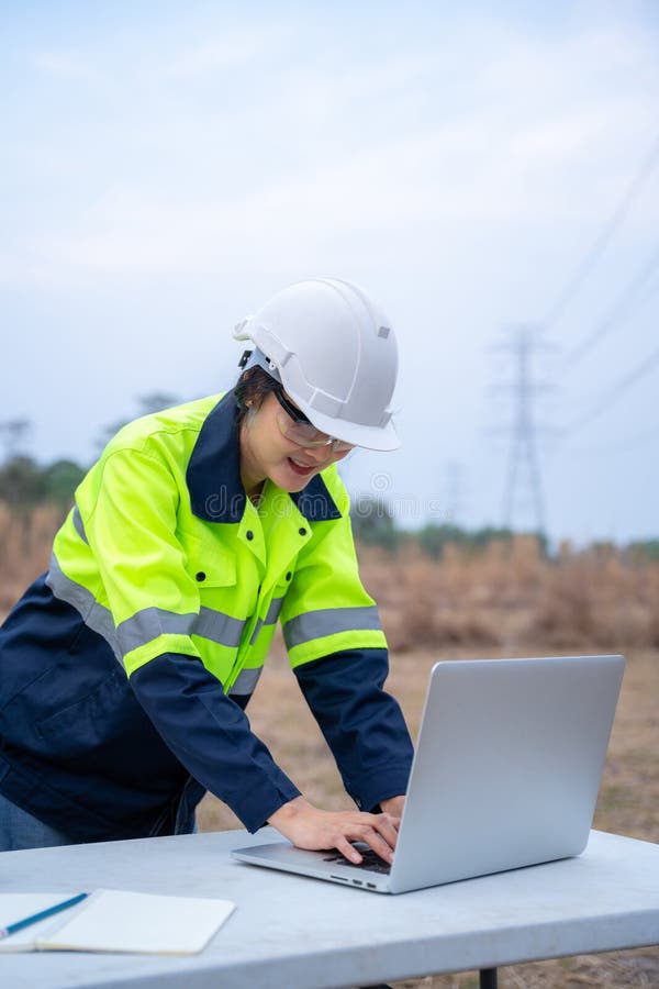 A Female Electrical Engineers Checking Location Using a Notebook Computer Standing at Power ...
