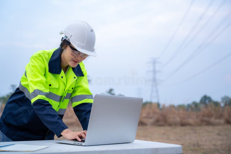 A Female Electrical Engineers Using a Notebook Computer Standing at ...