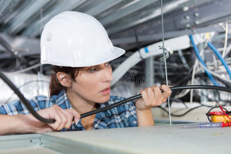 Female Electrician Checking Cable in Roof Space Stock Photo - Image of ...