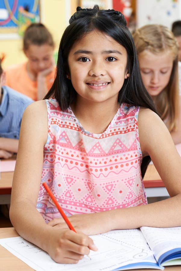 Female Elementary School Pupil Working at Desk Stock Image - Image of ...