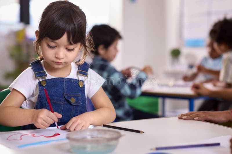 Female Elementary School Pupils Working at Table in Art Class at School ...