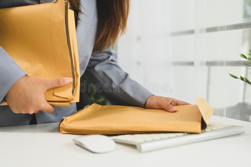 Female Employee Preparing Documents in Envelope for Business ...