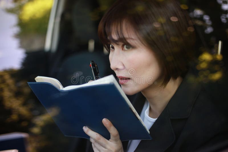 Female Employee Taking Notes in the Car Stock Image - Image of daytime ...