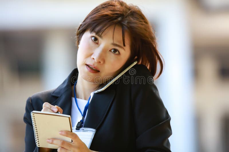 Female Employee Taking Notes while Talking on the Phone Stock Photo ...