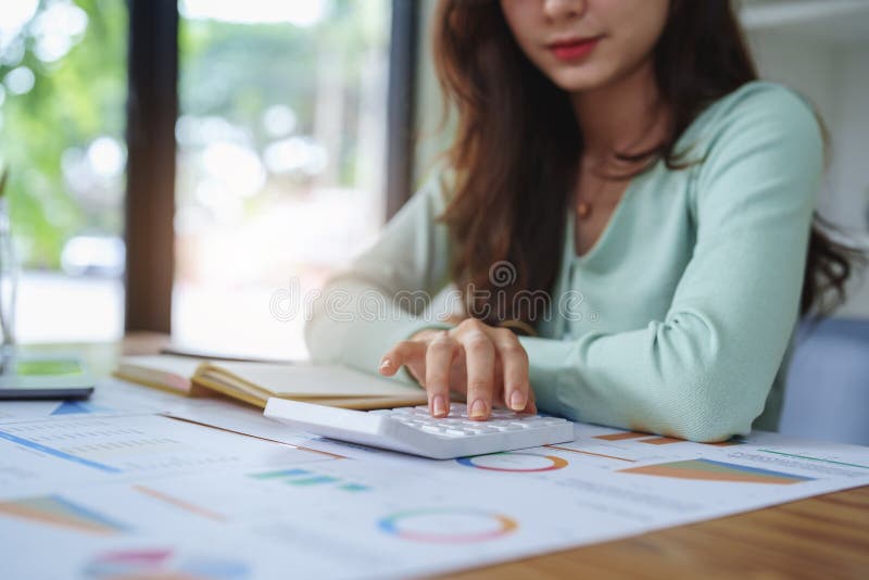 Female Employee Using a Calculator To Calculate Financial Documents ... Female Employee Using a Calculator To Calculate Financial Documents ...