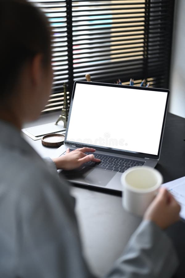 Female Employee Using Laptop Computer and Drinking Hot Coffee. Over ...
