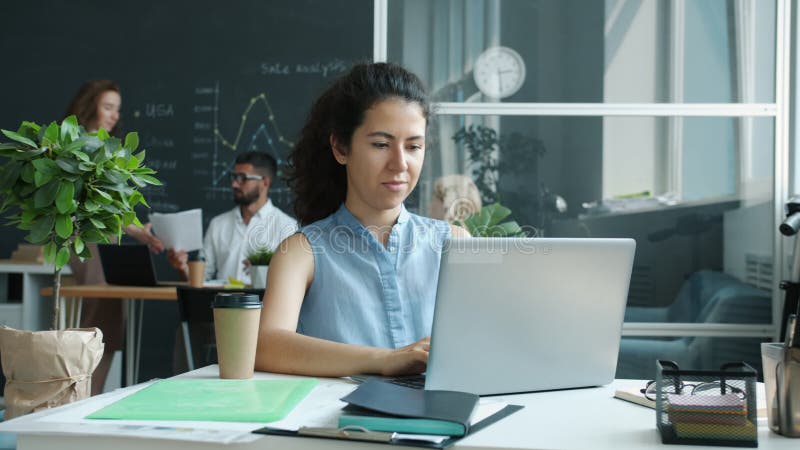 Female Employee Using Laptop Computer Typing Sitting at Desk in Shared ...