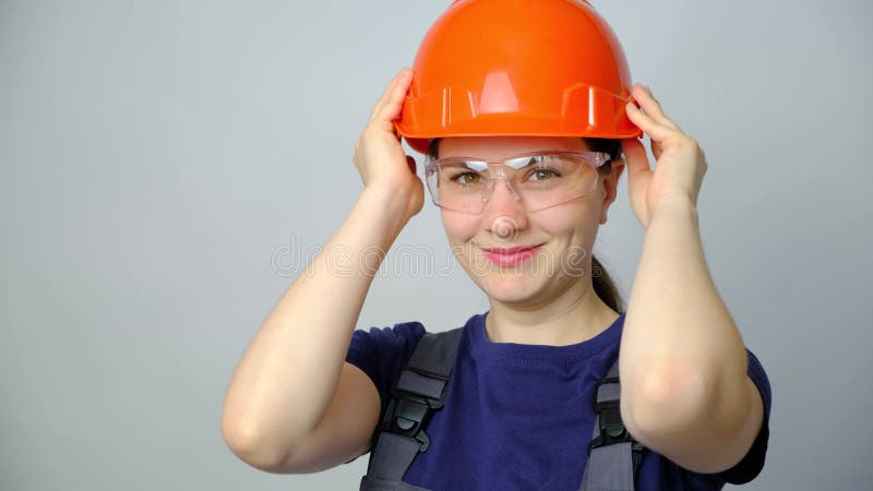 A Female Engineer or Builder Wears a Protective Helmet on a White ...