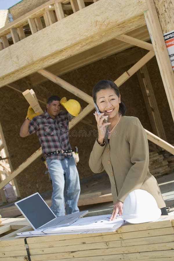 Female Engineer on Call with Worker at Site Stock Image - Image of ...
