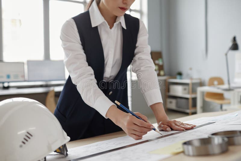 Female Engineer Drawing Blueprints and Plans at Workstation in Office ...