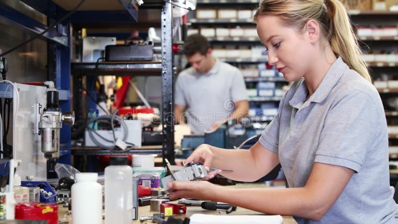 A Female Engineer in Work Overalls and a Helmet Wears Goggles on a ...