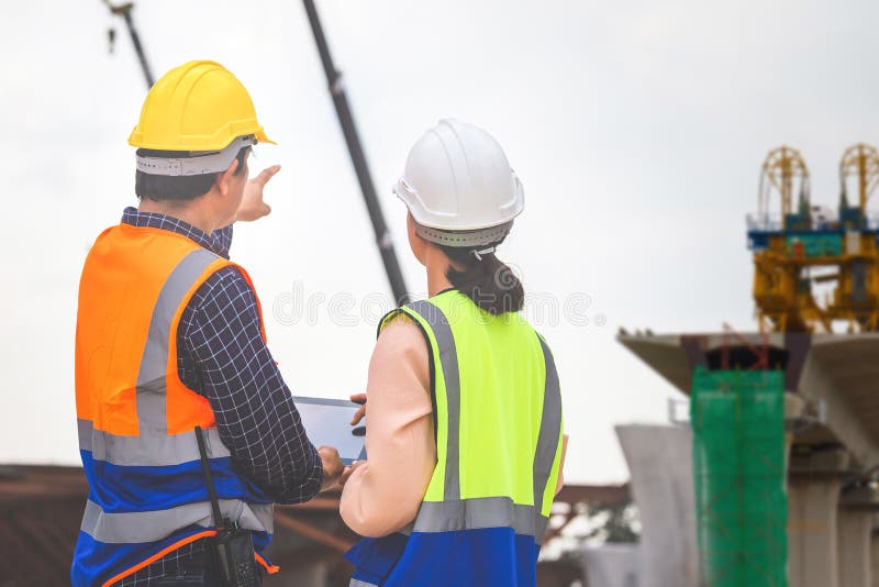 Female Engineer and Foreman Worker Checking Project at Building Site ...